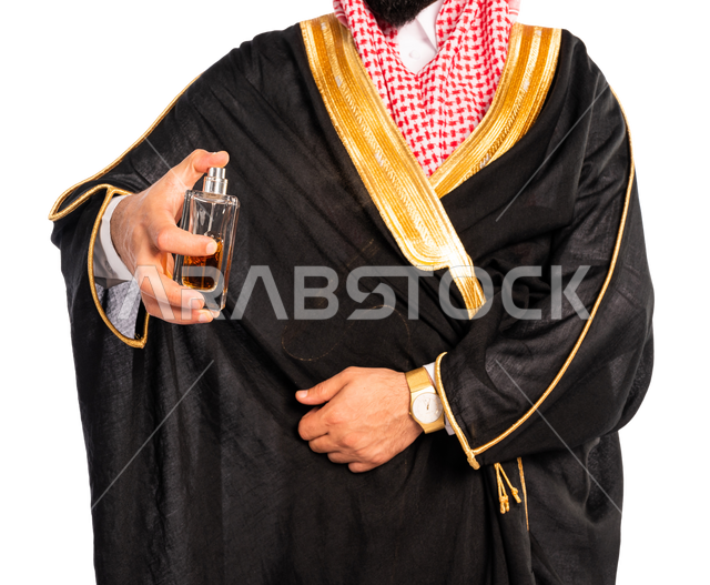 A close-up portrait of a Saudi Arabian Gulf groom in a black bisht ...