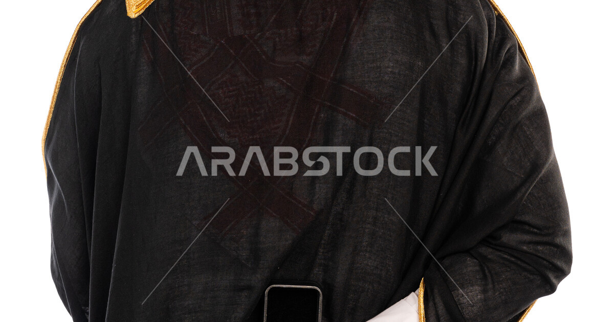 A close-up portrait of a Saudi Arabian Gulf groom in a black bisht ...