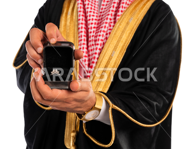 A close-up portrait of a Saudi Arabian Gulf groom in a black bisht ...