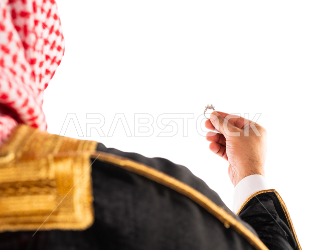 A close-up portrait of a Saudi Arabian Gulf groom in a black bisht ...