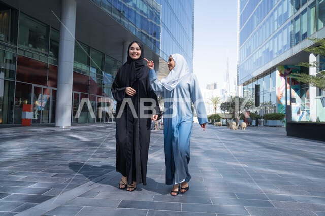 سيدتان اماراتيان تنظر ان النمو والتطور العمراني ، التجول واستنشاق ...