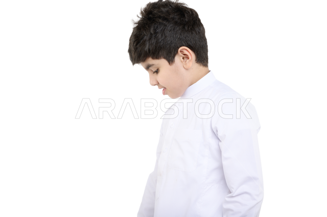 Portrait of a smiling Saudi Arabian Gulf Arab boy looking down with ...