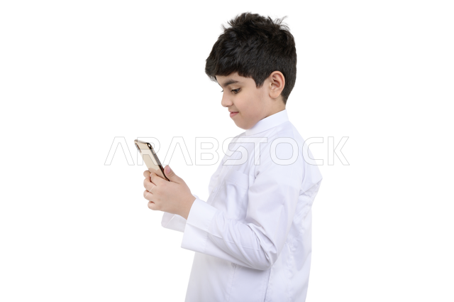 Portrait of a smiling Saudi Arabian Gulf Arab boy with a mobile phone ...