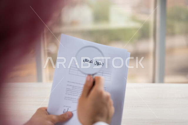 Close-up of the hand of a Saudi Arabian Gulf man holding a magnifying ...