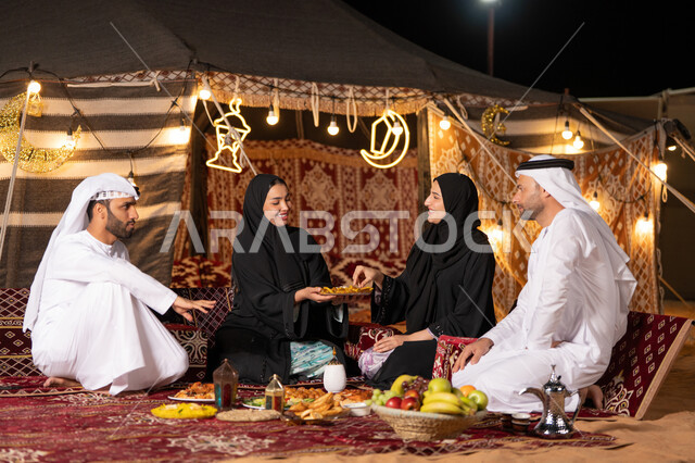 An Emirati Gulf Arab family sitting in a tent at breakfast time, an ...