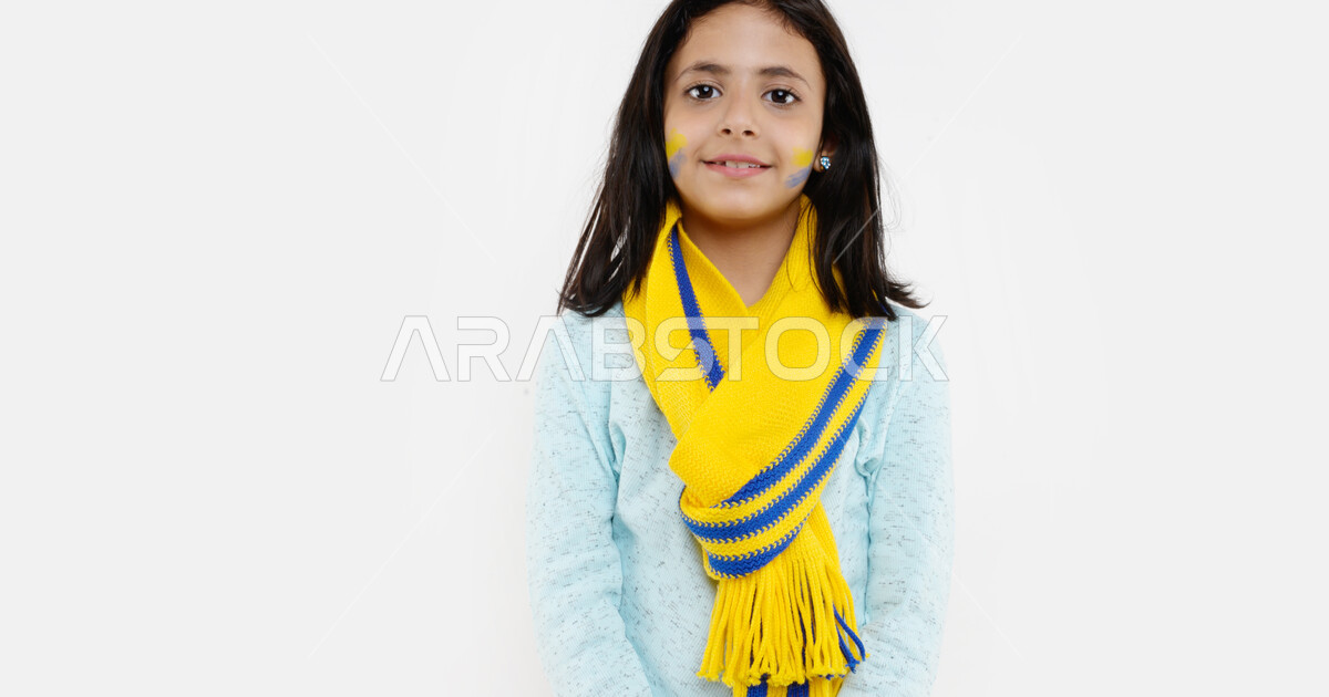 Portrait of a smiling Saudi Arabian Gulf Arab girl cheering the Saudi ...