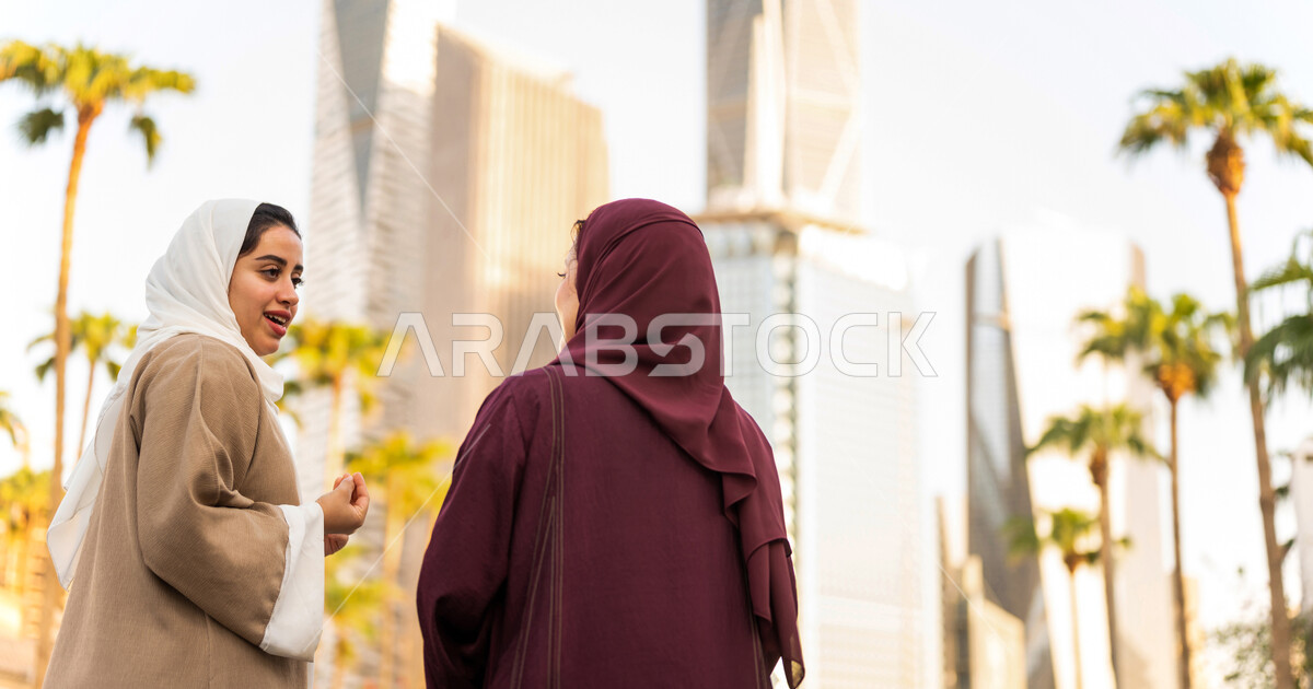 Two Saudi Arabian Gulf ladies talking to each other, touring in King ...