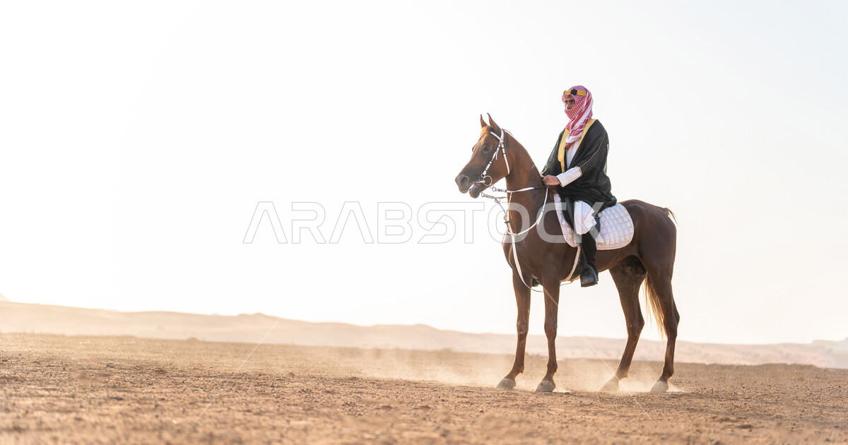 A Saudi Gulf rider riding horses in the picturesque Saudi desert in the ...