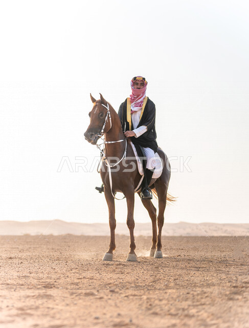 A Saudi Gulf rider riding horses in the picturesque Saudi desert in the ...