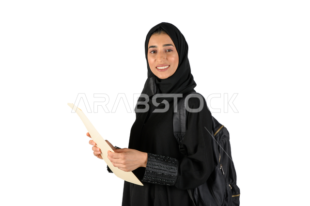 Portrait of a veiled Saudi Arab university student holding a university ...