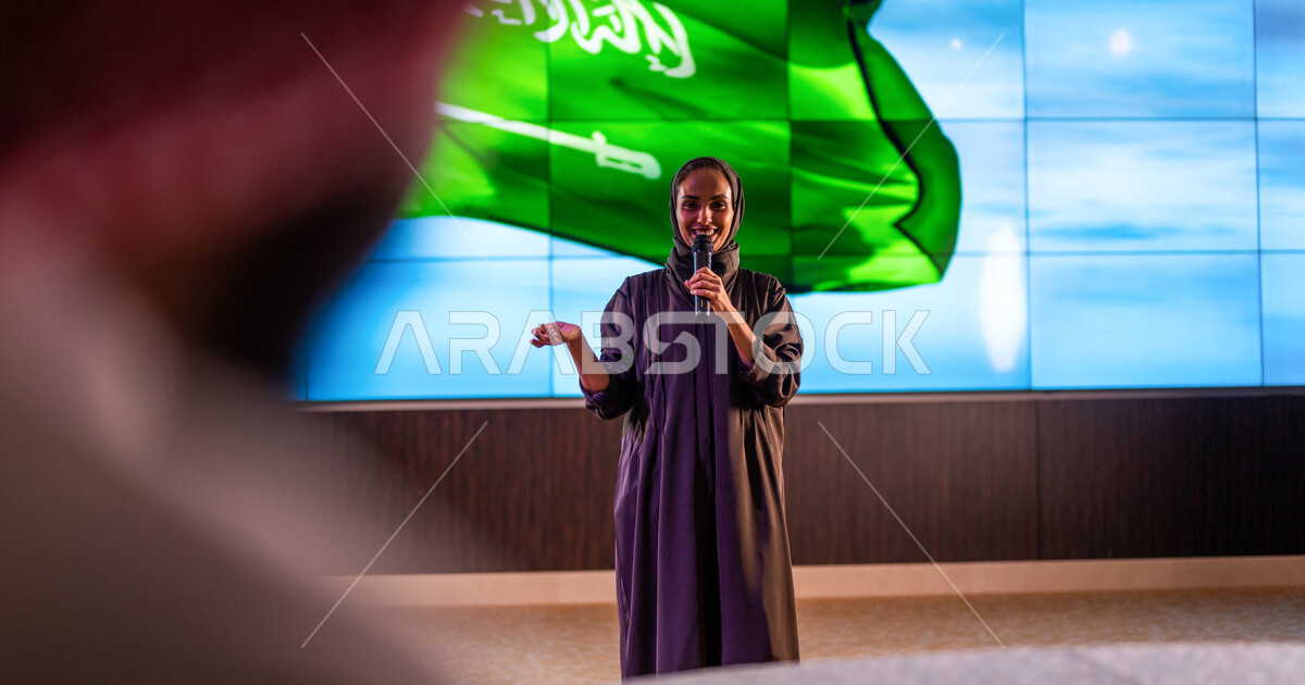 A Saudi Arabian Gulf woman standing in front of a background of the ...