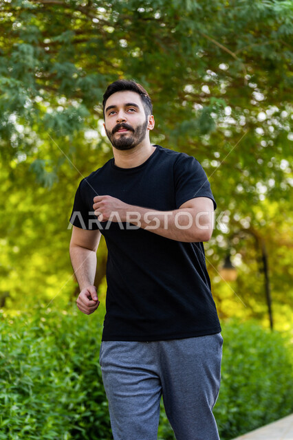 An Arab man doing morning sports in the open air, jogging, exercising ...