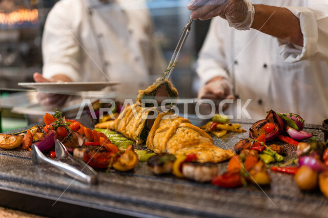 A Saudi Arabian Gulf cook prepares food to be served in the restaurant ...
