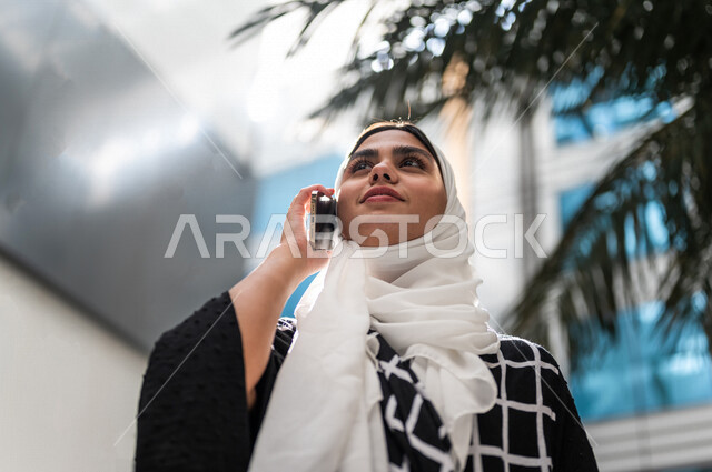 A Saudi Arabian Gulf woman inside the tourist hotel, making a phone ...