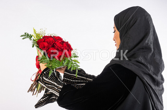 Portrait of a Saudi Arabian Gulf woman holding a beautiful red rose ...