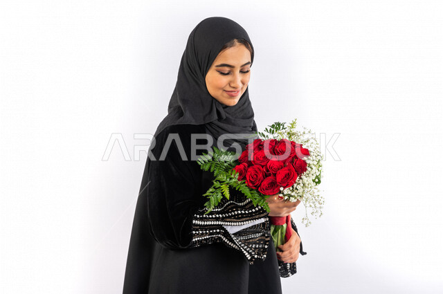 Portrait of a Saudi Arabian Gulf woman holding a beautiful red rose ...