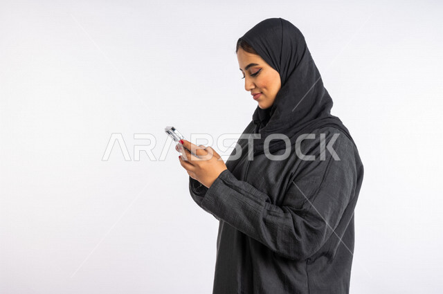 Portrait of a Saudi Arabian Gulf woman, using a mobile phone ...