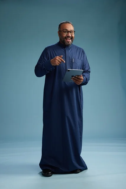 A portrait of an Arab Saudi Gulf man in traditional attire standing ...