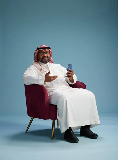 A portrait of a Saudi Arabian Gulf man wearing a white thobe sitting on ...