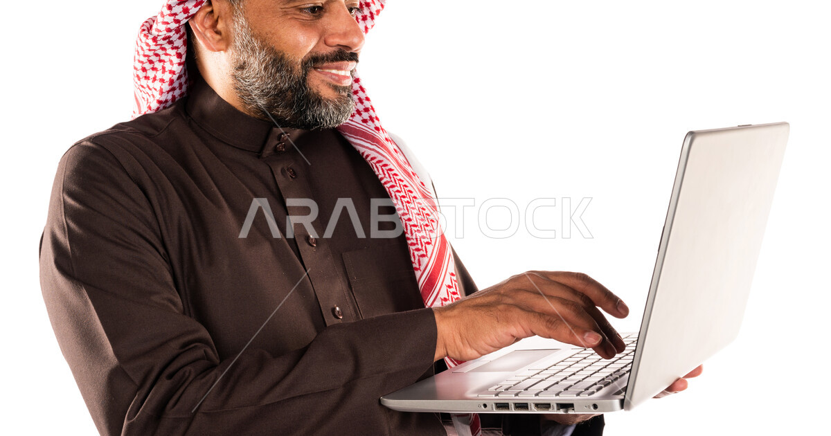 Portrait of a Saudi Arabian Gulf man holding a laptop computer ...