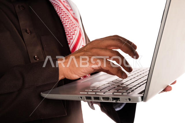 Portrait of a Saudi Arabian Gulf man holding a laptop computer ...