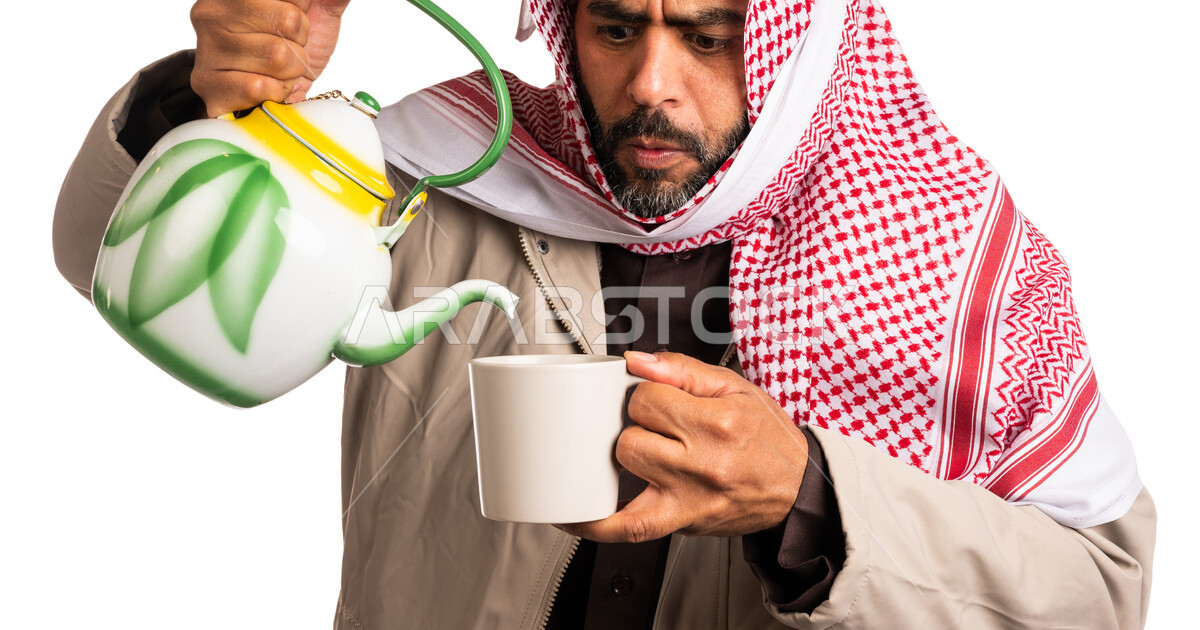 Portrait of a Saudi Arabian Gulf man in warm winter clothes holding a ...