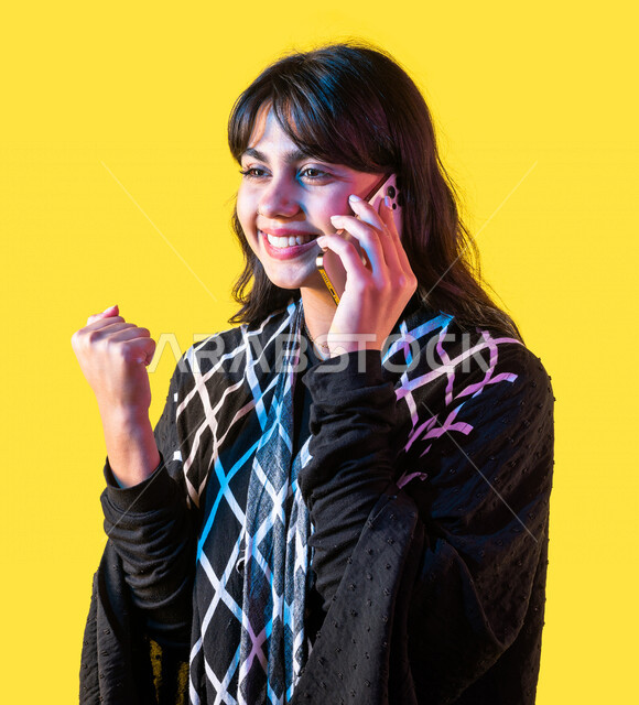 Portrait of a young Saudi Arabian Gulf woman, making a mobile phone ...