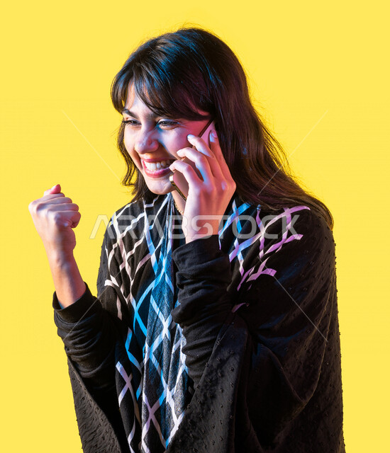 Portrait of a young Saudi Arabian Gulf woman, making a mobile phone ...