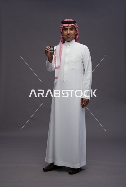Saudi Man in Traditional Dress Holding a Car Key - Photo