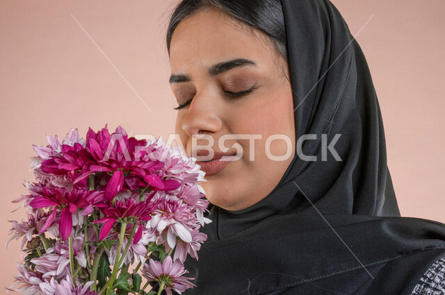 Portrait of a Saudi Arabian Gulf woman holding beautiful roses in her ...