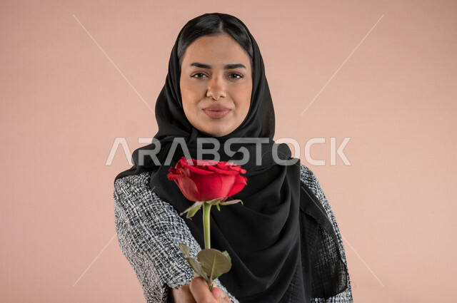 Portrait of a Saudi Arabian Gulf woman holding beautiful roses in her ...