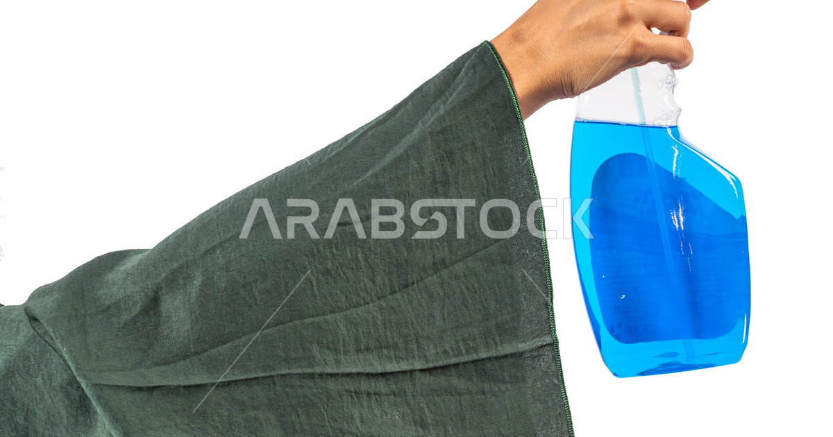 A close-up of a Saudi Gulf woman, holding in her hand household ...