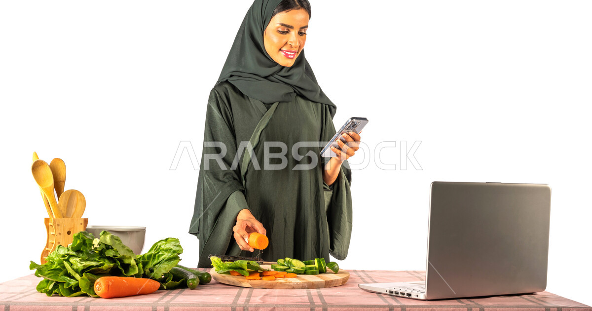 Portrait of a Saudi Gulf woman, standing in front of a table with a ...