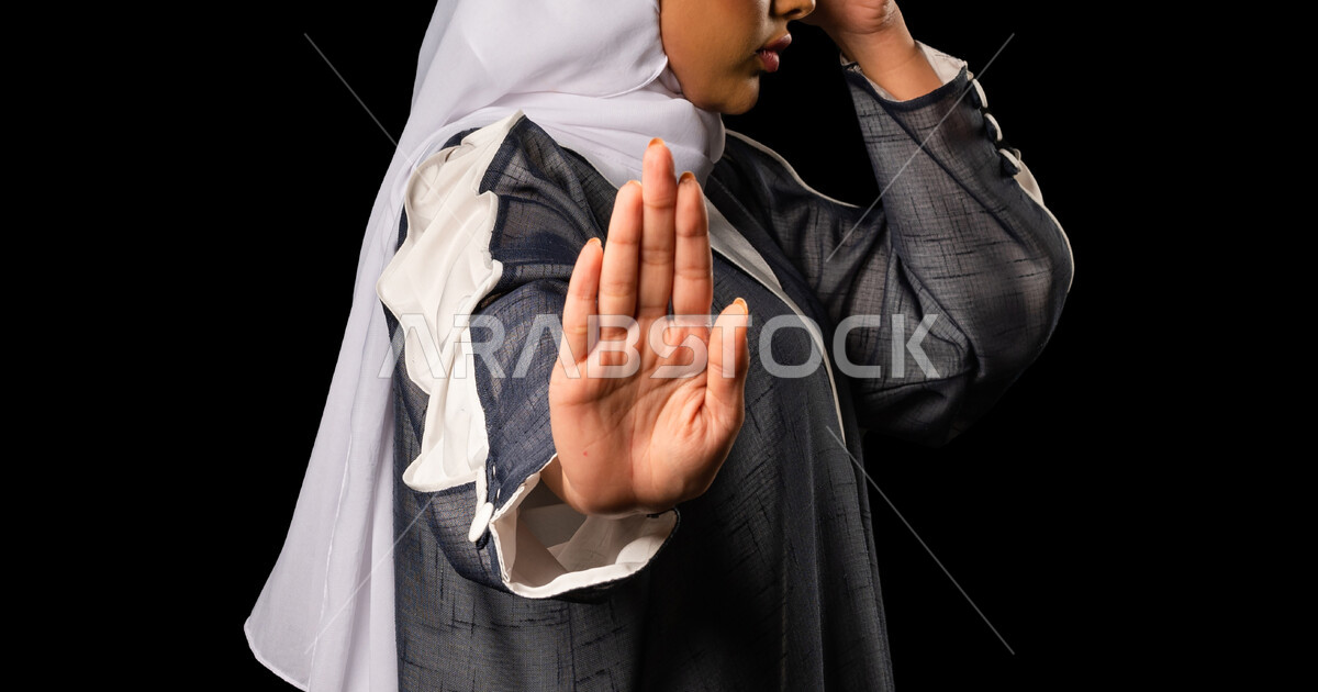 Portrait of a Saudi Arabian Gulf woman covering her face with her hand ...