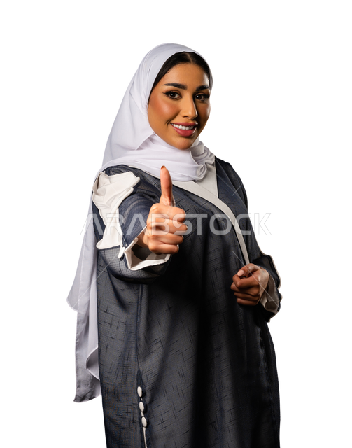 Portrait of a happy Saudi Arabian Gulf woman raising her thumbs up with ...