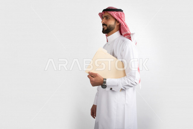 Portrait of a Saudi Arabian Gulf male smiling with a yellow file ...