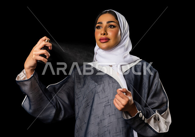 Portrait of a Saudi Arabian Gulf woman spraying perfume, women's ...