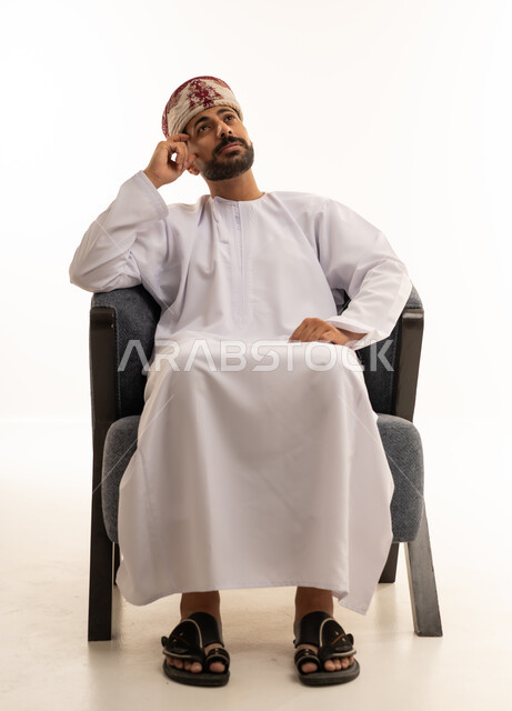 Thinking Omani Man in Traditional Dishdasha and Kumma - Photo