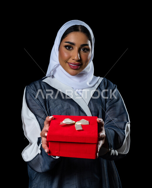 Portrait of a Saudi Arabian Gulf woman wearing a Saudi abaya holding a ...
