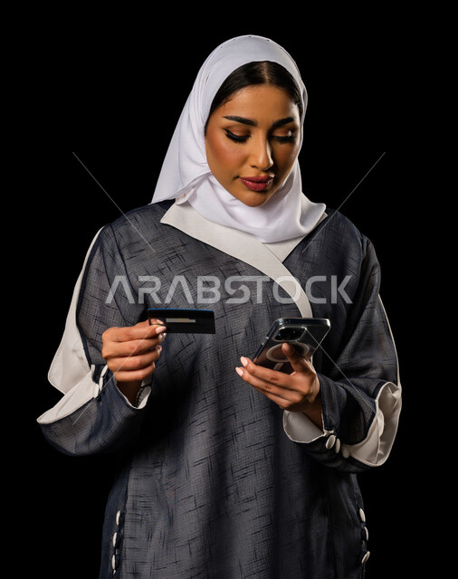 Portrait of a Saudi Arabian Gulf woman, holding a mobile phone for ...