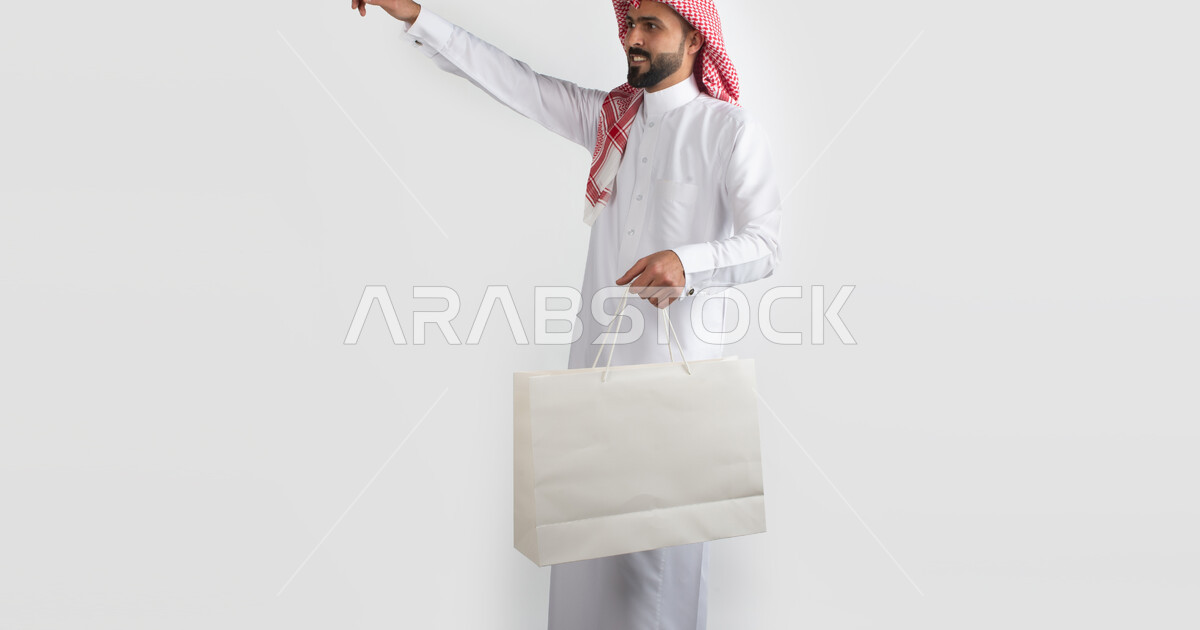 Portrait of a Saudi Arabian man carrying a white bag, a Saudi Gulf ...