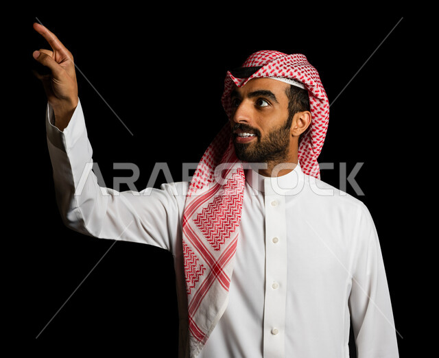 A Saudi Arabian Gulf man wearing the Saudi dress and pointing to ...