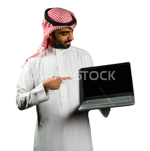 A Saudi Arabian Gulf man wearing a Saudi dress, using a laptop computer ...