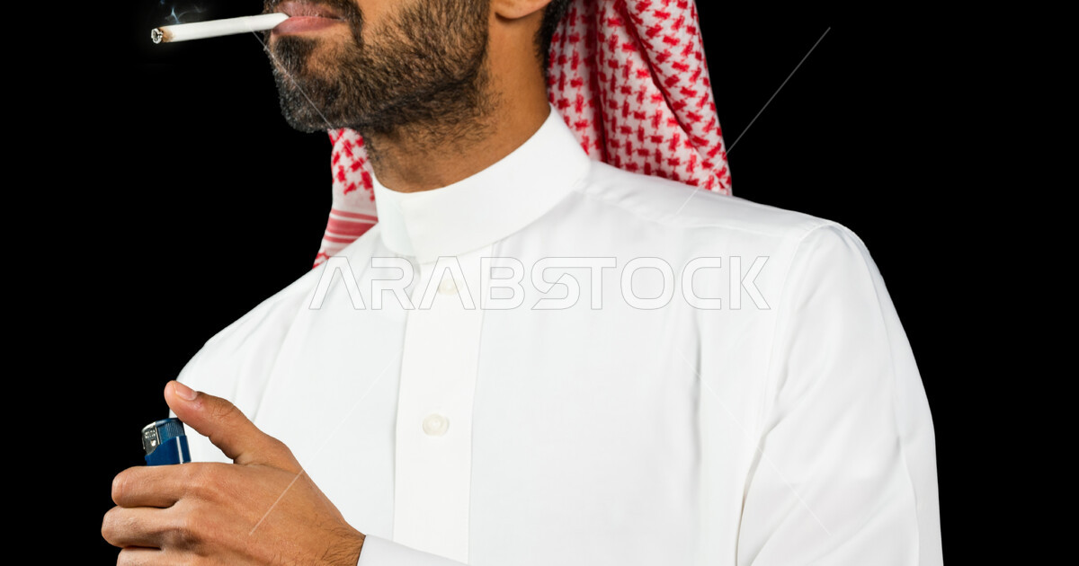 A Saudi Arabian Gulf man wearing a Saudi dress smoking cigarettes ...