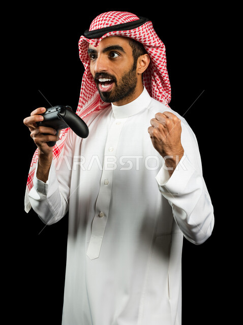 A young Saudi Arabian Gulf man wearing a Saudi outfit, holding a ...