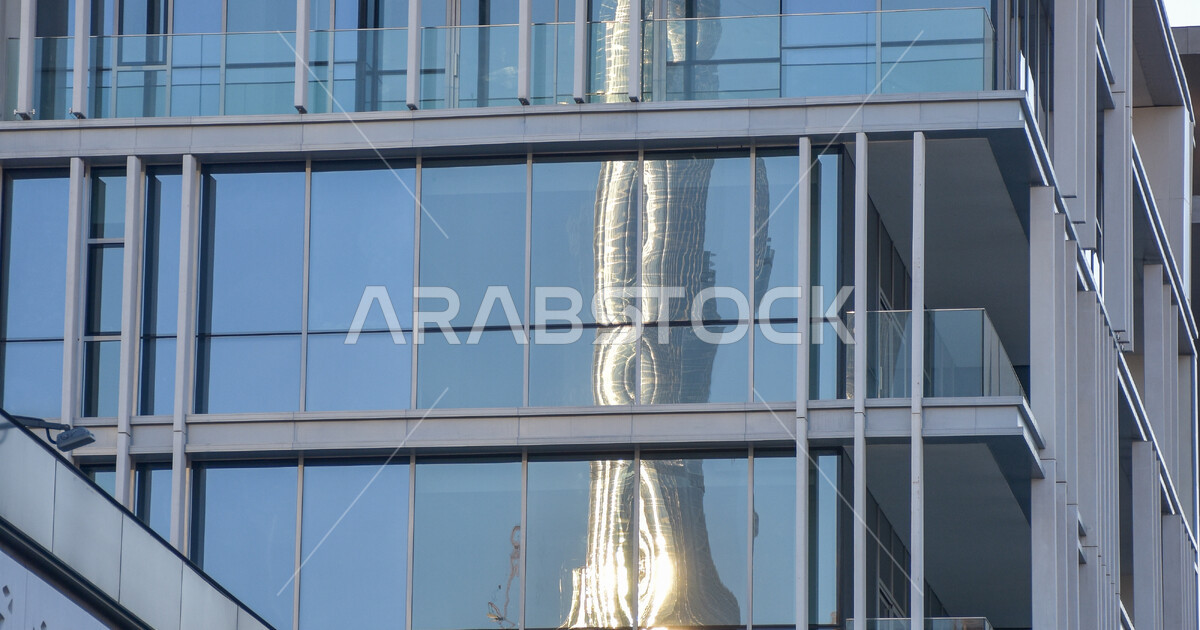 A reflection of the Burj Khalifa in the glass of a skyscraper in Dubai ...