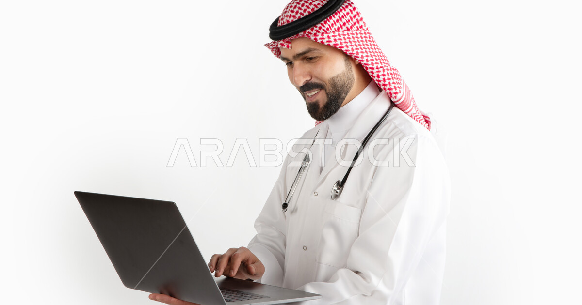 Portrait of a Saudi Saudi Arabian Muslim man using a laptop, white ...