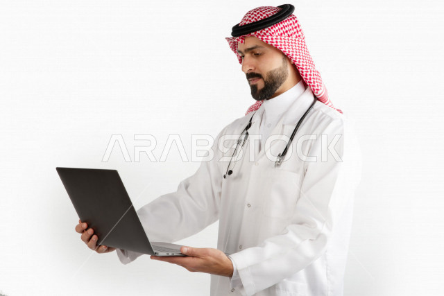 Portrait of a Saudi Saudi Arabian Muslim man using a laptop, white ...