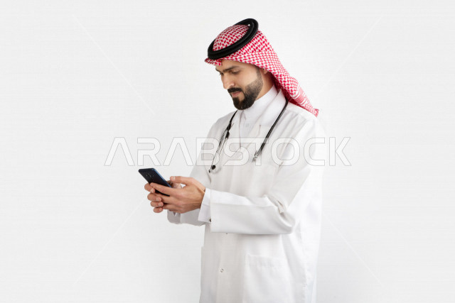 Portrait of Saudi Arabian Muslim man, man, using mobile phone, white ...