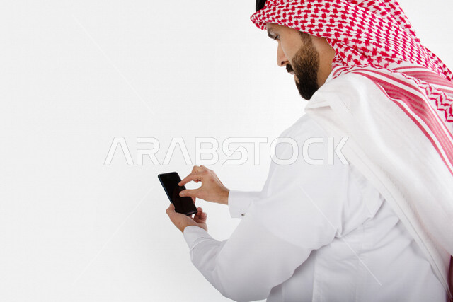 Close-up of a Saudi Arabian Gulf man, traditional Saudi clothing, using ...